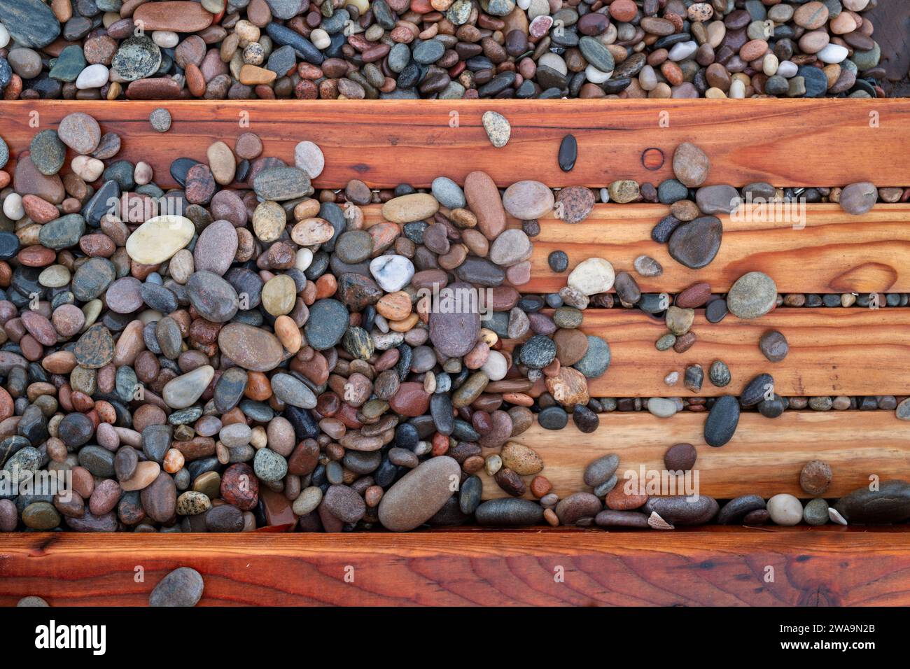Pebbles on wooden steps thrown up by the windy sea at high tide on ...