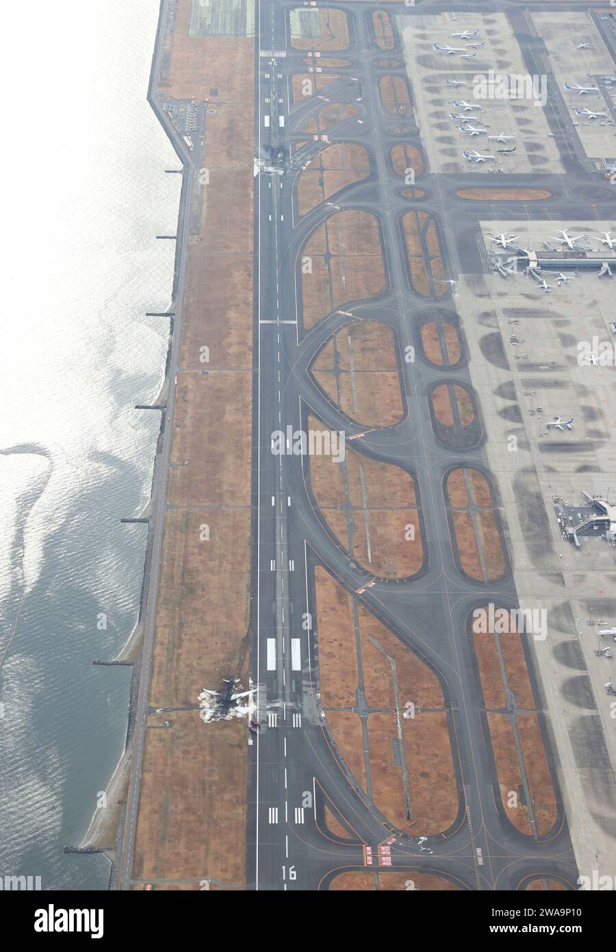 An aerial photo shows Japan Airlines flight 516 burnt on the runway at ...