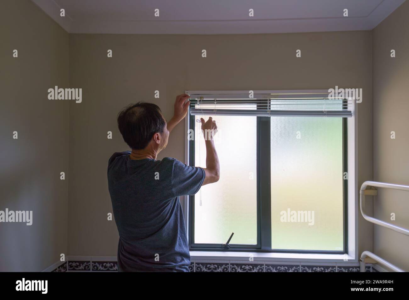 Man installing bathroom blinds. Home renovation project Stock Photo - Alamy