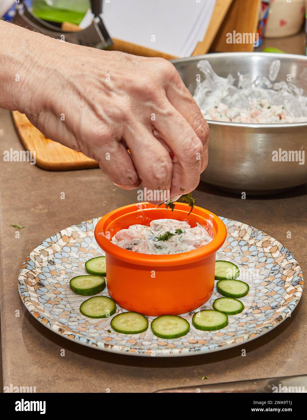 Hands of a skilled chef carefully assemble a delicious tartar dish with ...