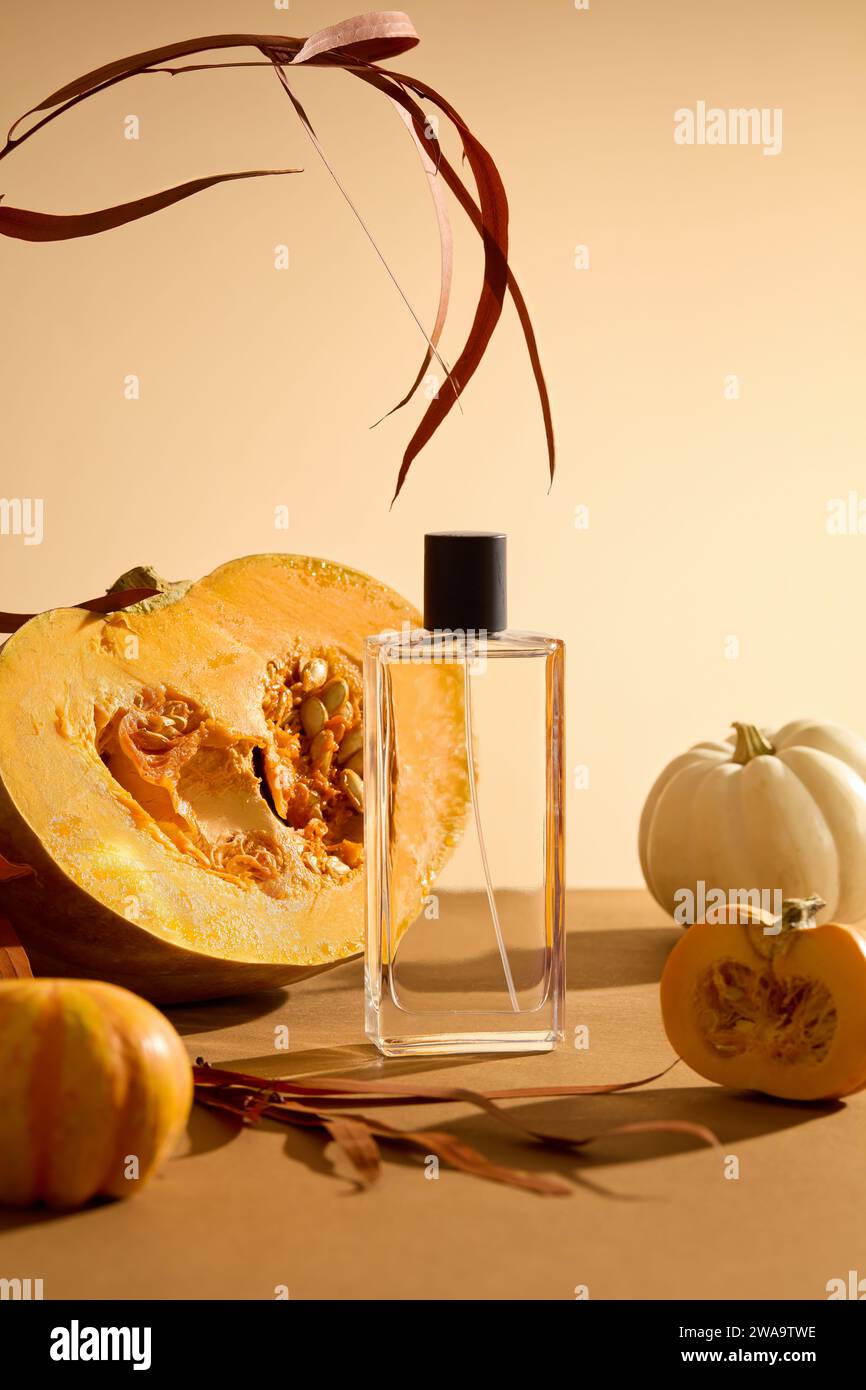 Transparent bottle of perfume decorated with halves of pumpkin ...