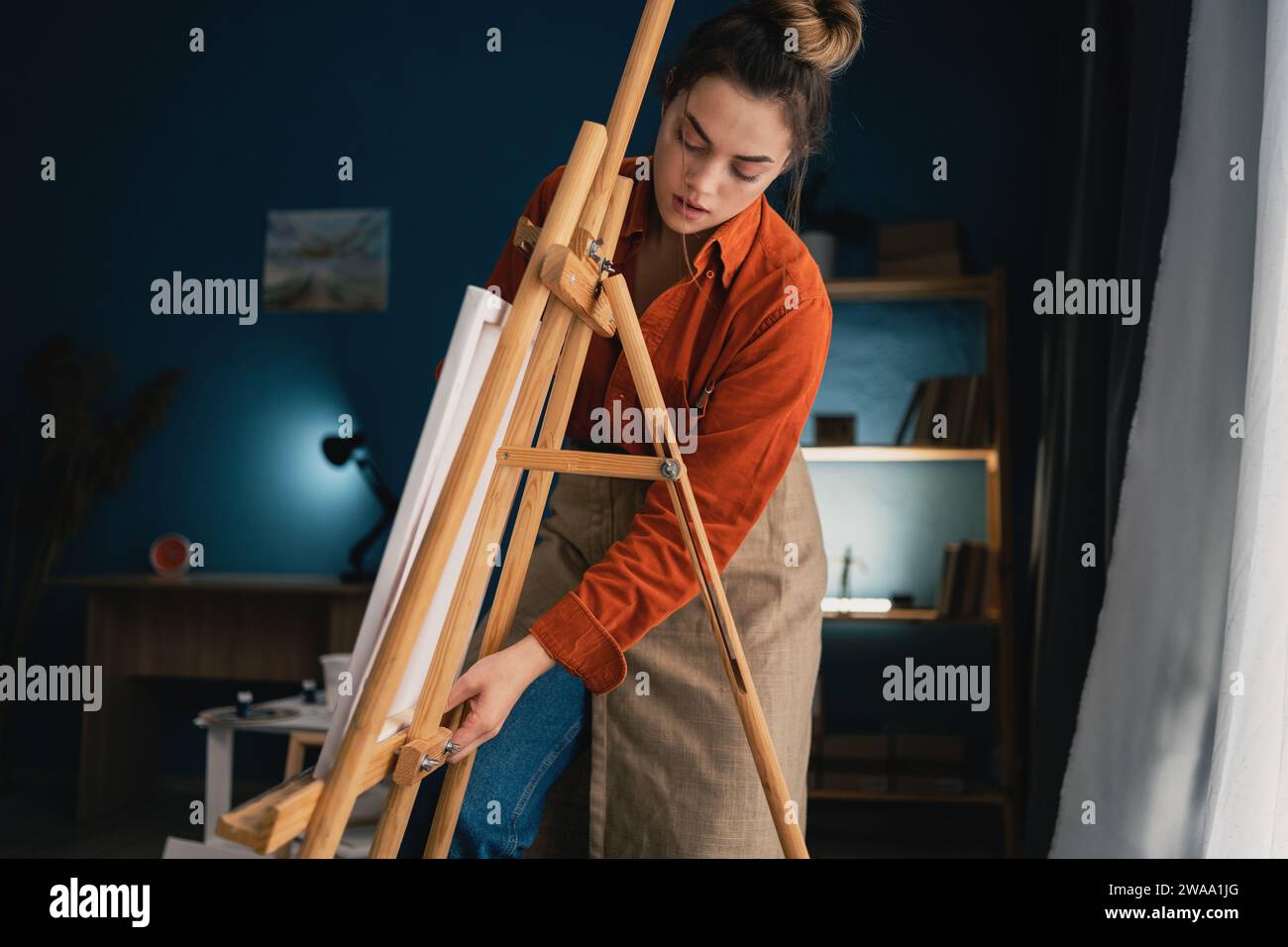 Creative latin female artist standing working on a new painting. Happy ...