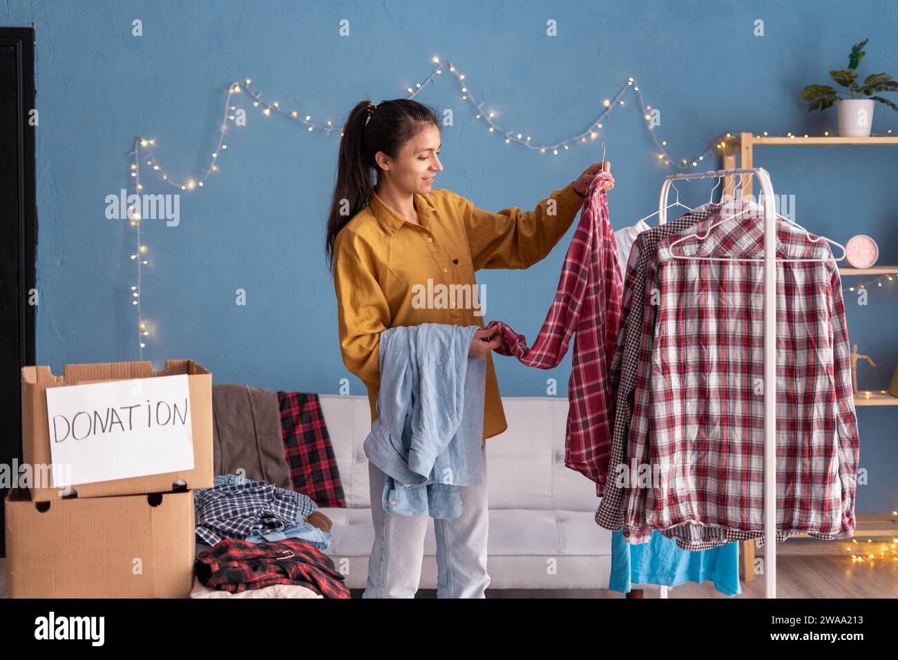 Second-hand concept. Latin woman selecting clothes from her wardrobe ...