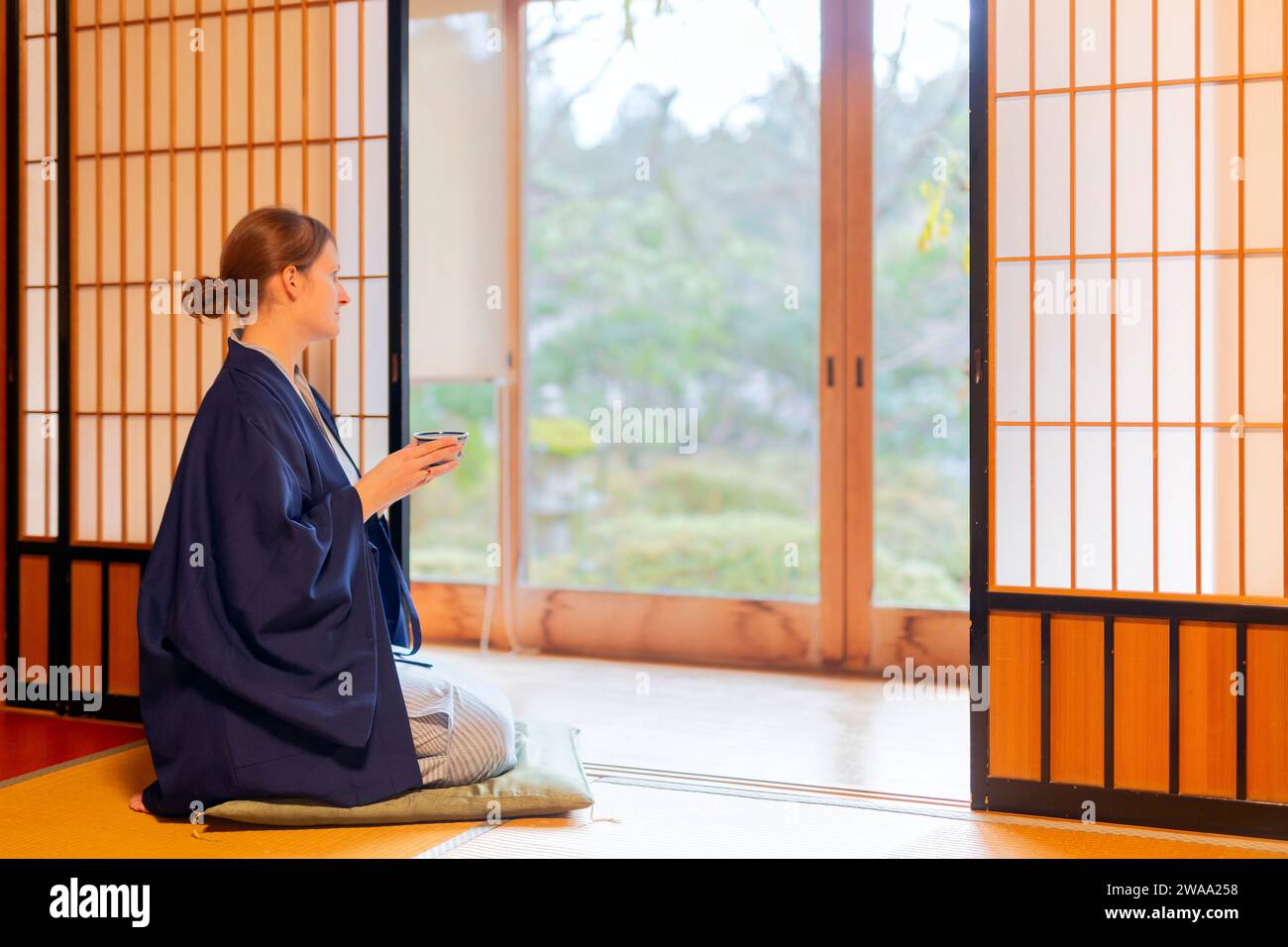 A young caucasian woman is relaxing at a traditional Japanese drinking ...