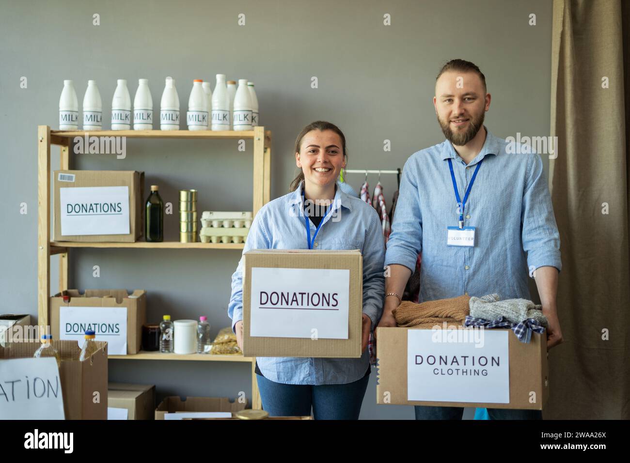 Happy smiling volunteer team with food in boxes at distribution or ...