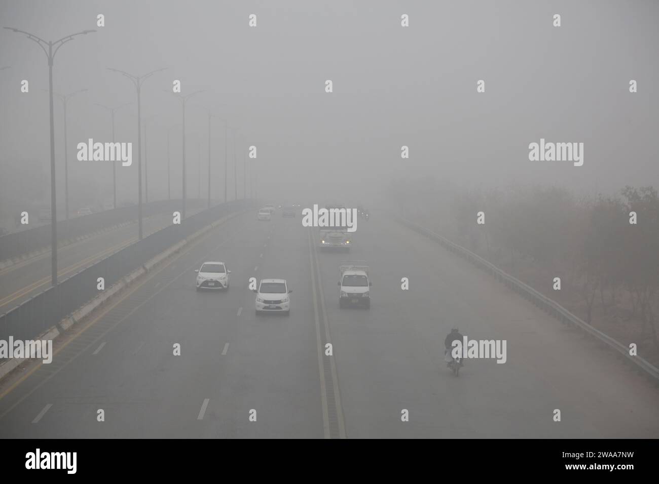 Islamabad. 3rd Jan, 2024. Vehicles move amid heavy fog on a road in ...