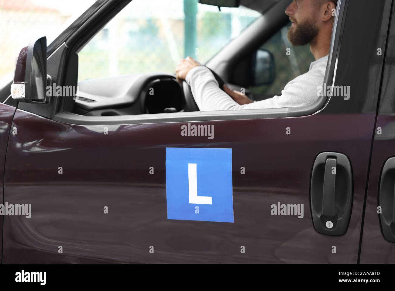 Learner driver driving car with L-plate, view from outside. Driving ...