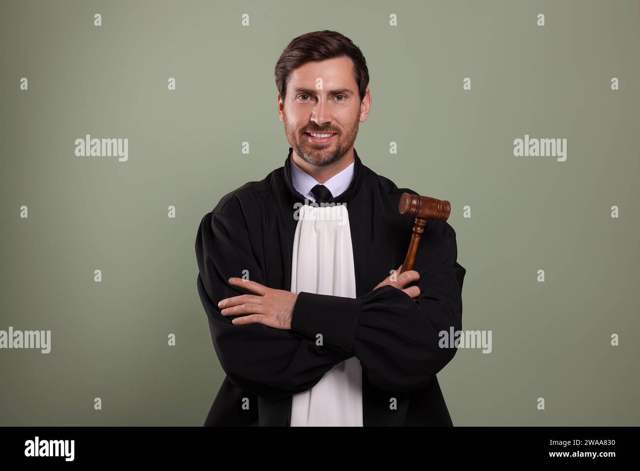 Happy judge with gavel on green background Stock Photo - Alamy