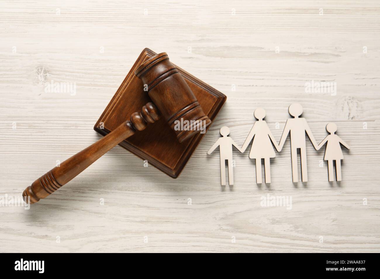Law concept. Gavel and figures of parents with children on white wooden ...