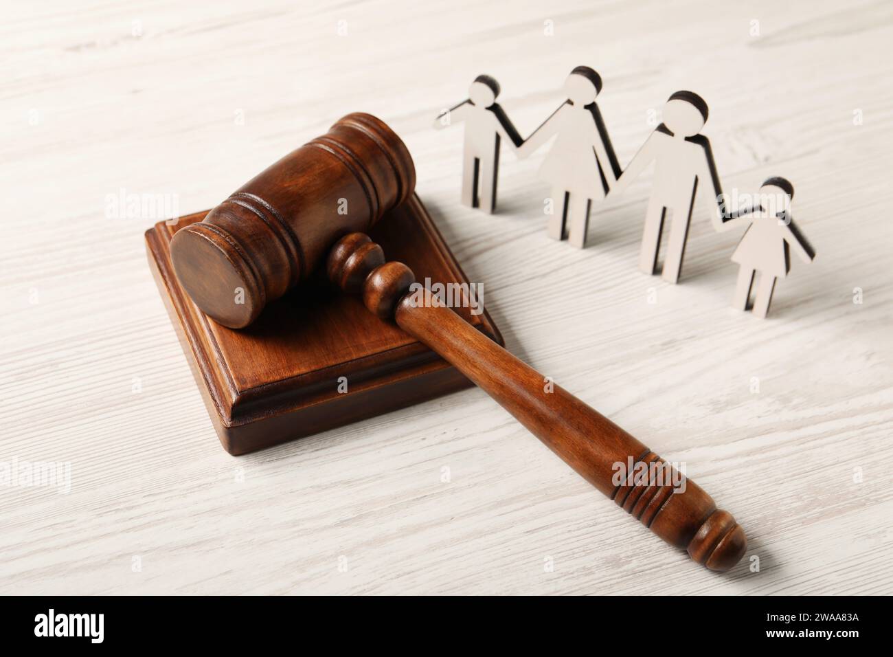 Law concept. Gavel and figures of parents with children on white wooden ...