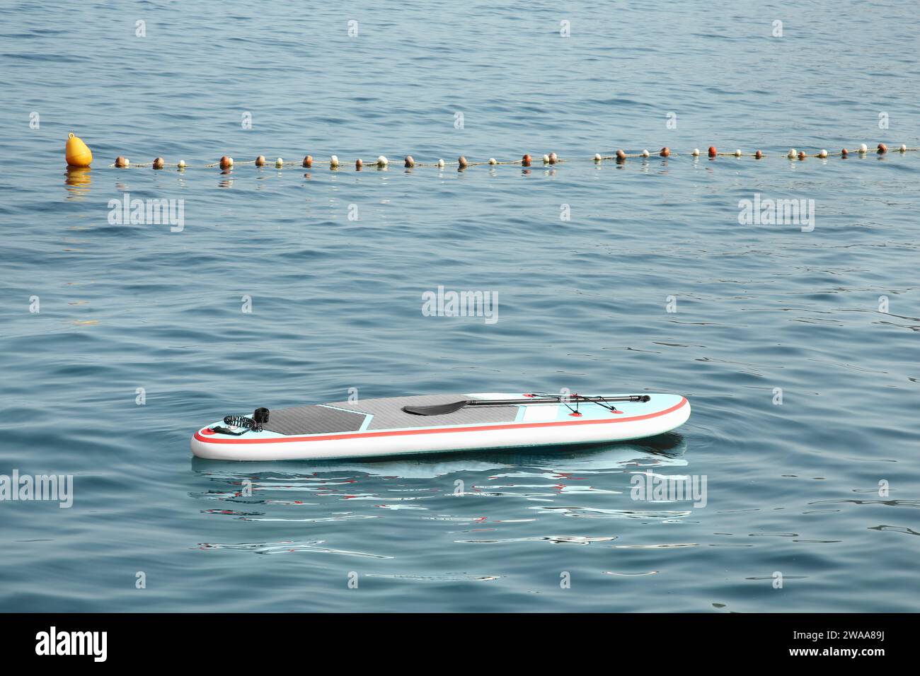 One SUP board with paddle on water in sea Stock Photo - Alamy