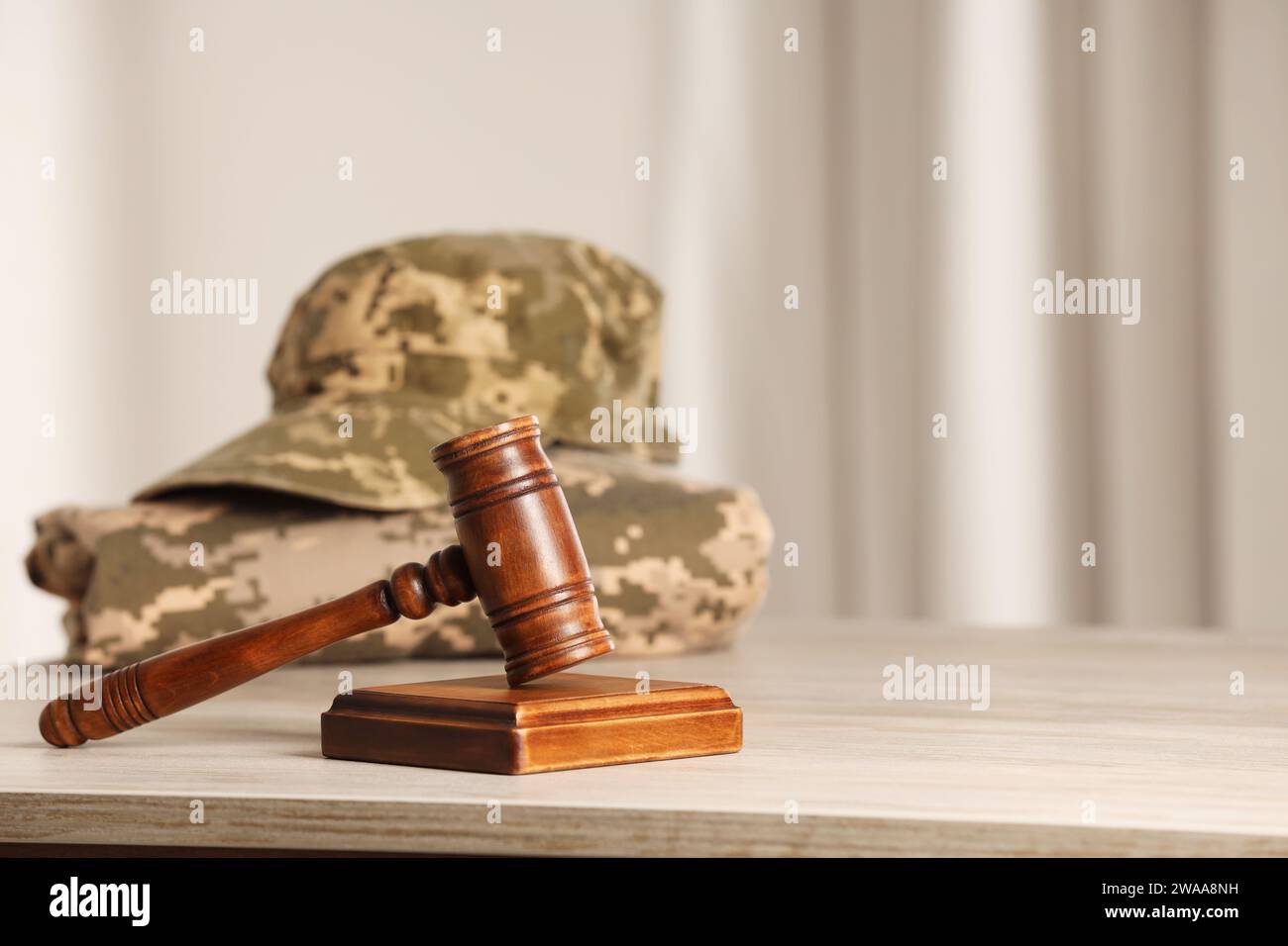 Law concept. Gavel and military uniform on wooden table, space for text ...