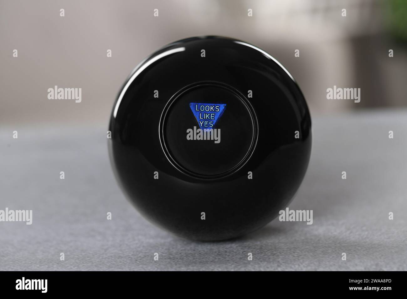 Magic eight ball with prediction Looks Like Yes on light gray table ...