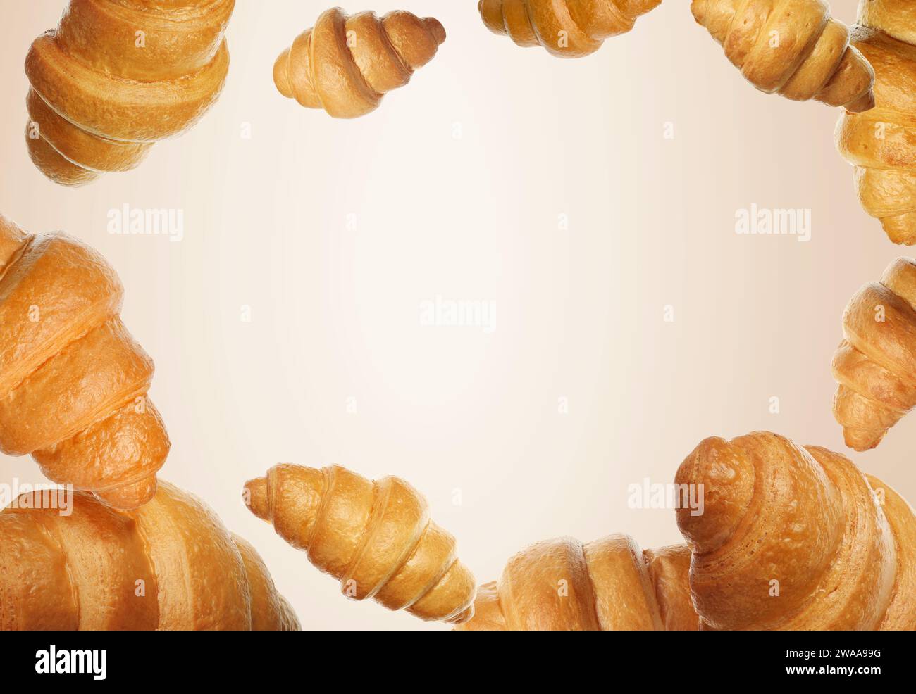 Golden croissants falling on beige gradient background Stock Photo - Alamy