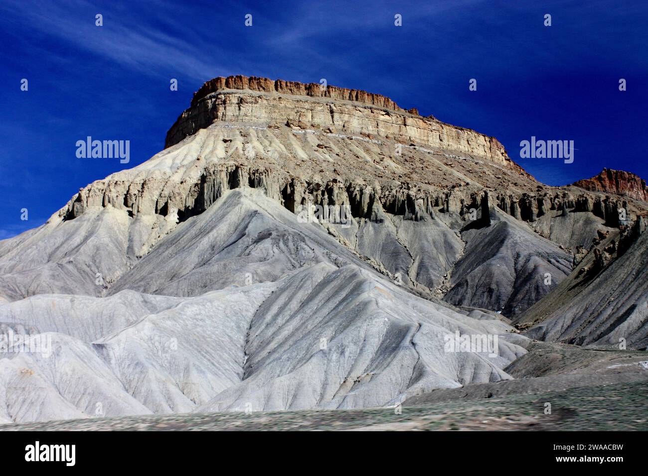 the dramatically-eroded cliffs of mount garfield against a blue sky ...