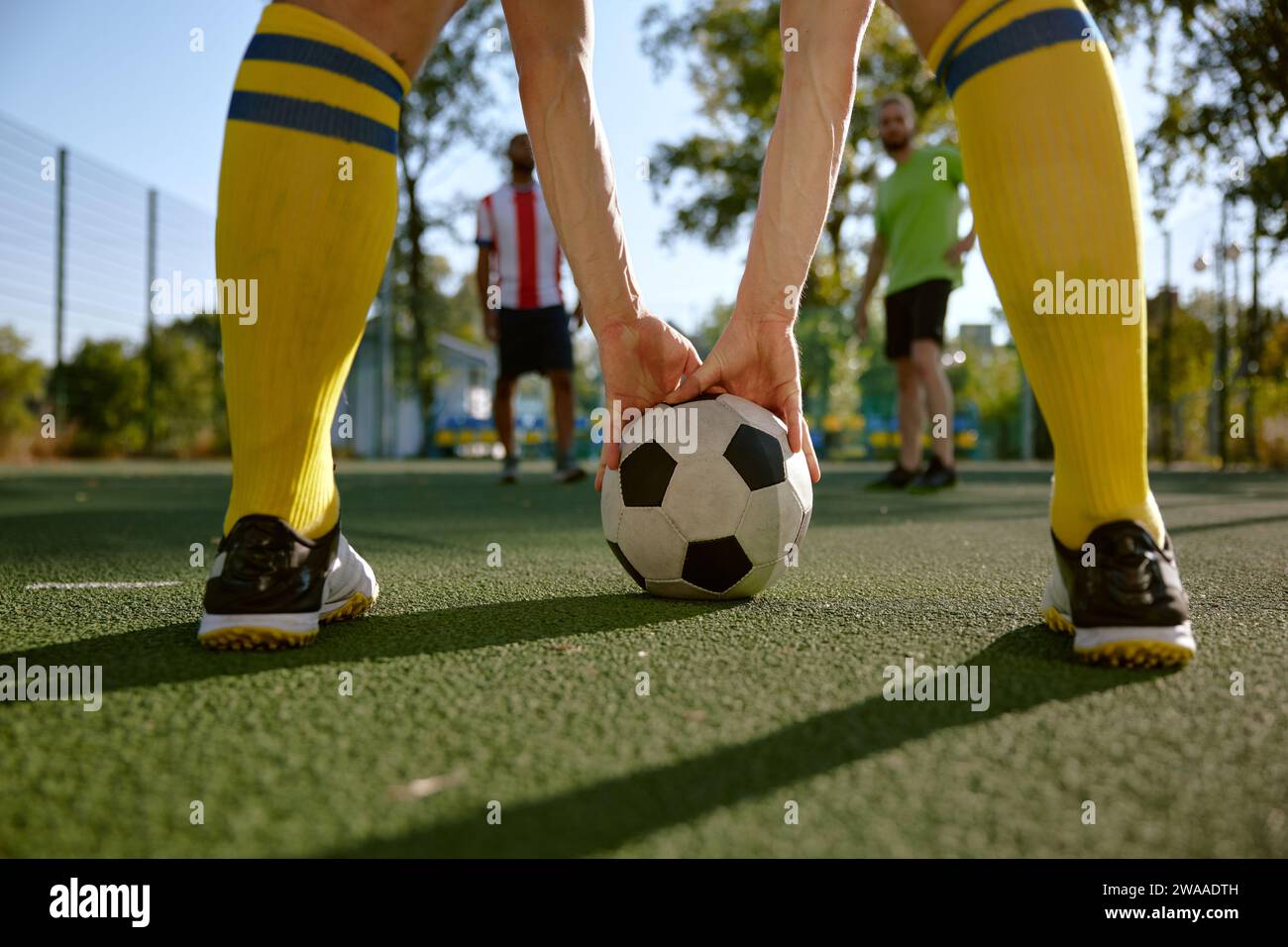 Soccer ball and sportsman legs over grass football field Stock Photo ...