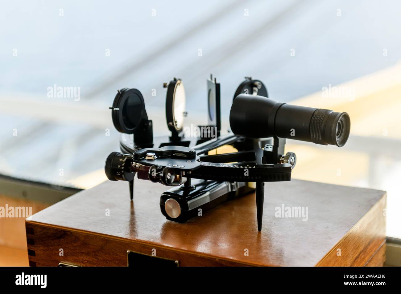 Nautical black sextant placed on wooden box in navigational bridge ...