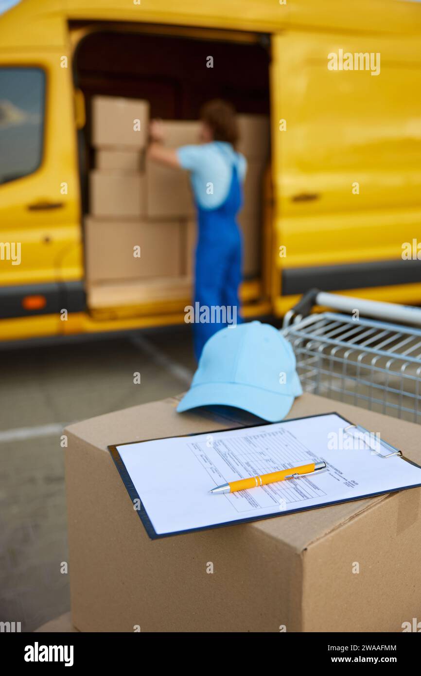 Man loader packing boxes into minivan, focus on delivery checklist ...