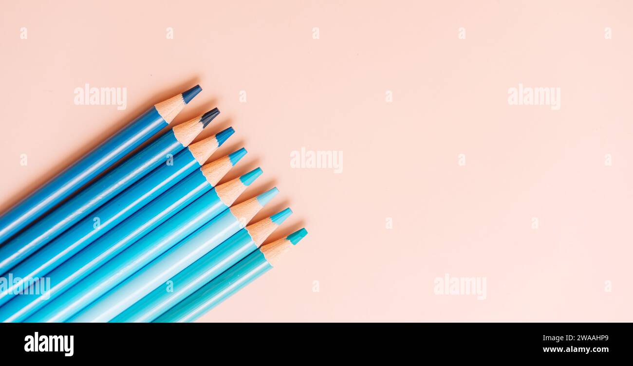 Blue pencils lie in a row on a beige background Stock Photo - Alamy