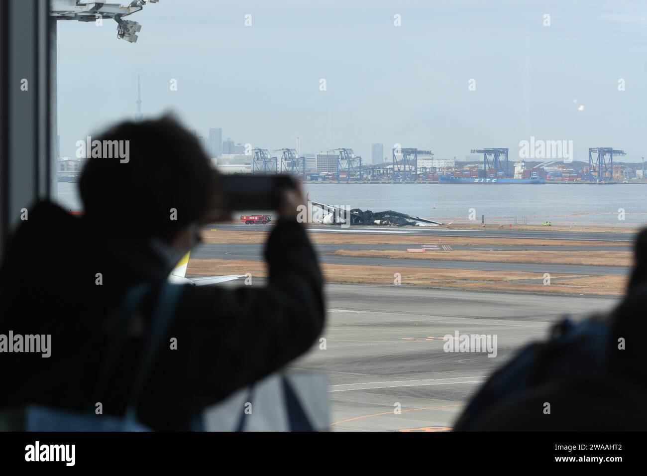 Tokyo, Japan. 3rd Jan, 2024. Passengers look at the wreckage of JAL ...