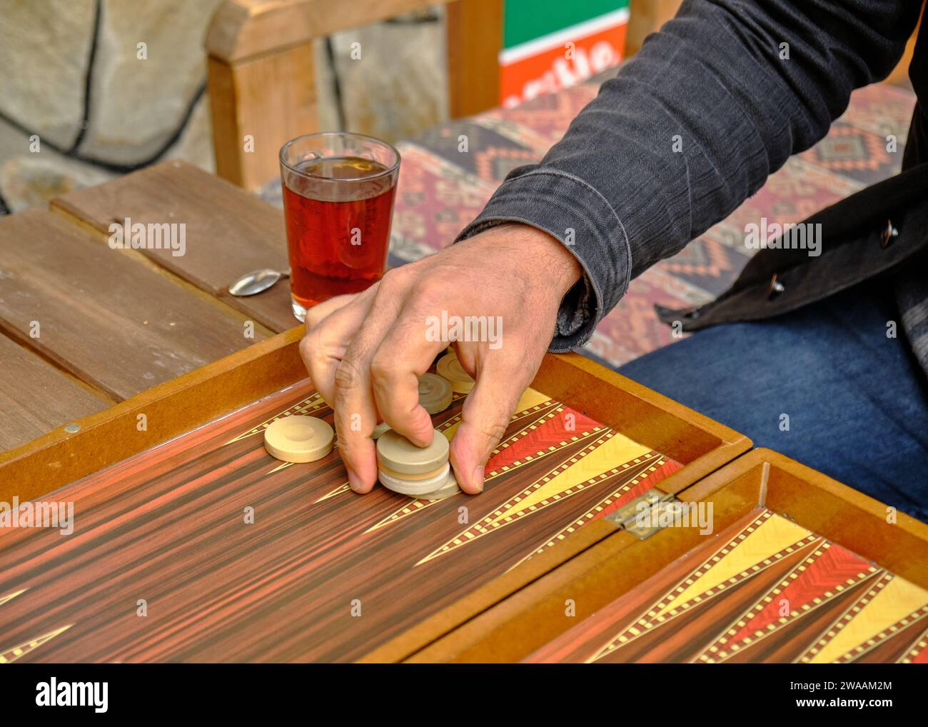Man hand picking up four pieces from backgammon board game in outdoor ...