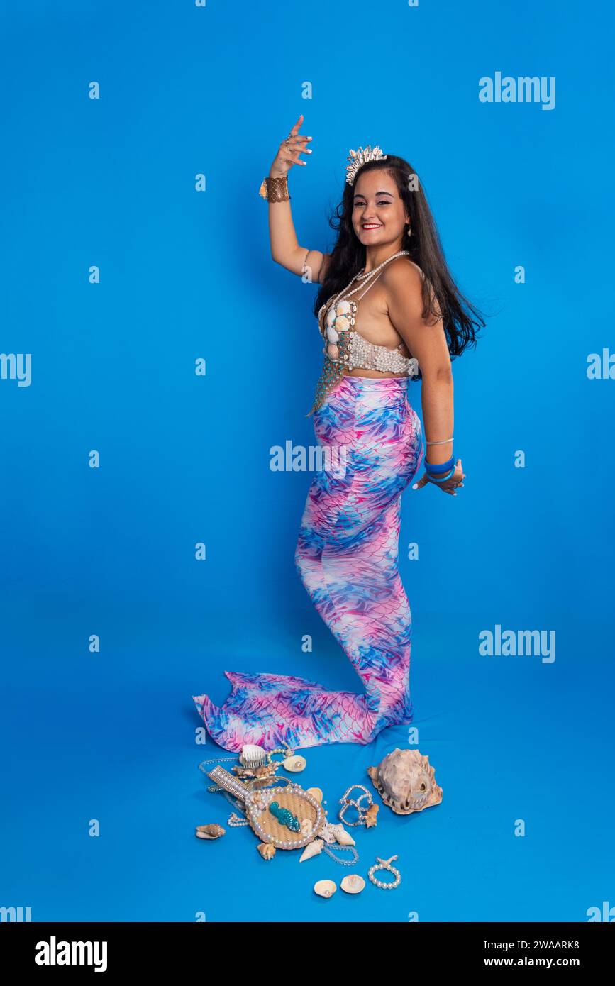 Beautiful woman dressed as a mermaid, standing next to several sea ...