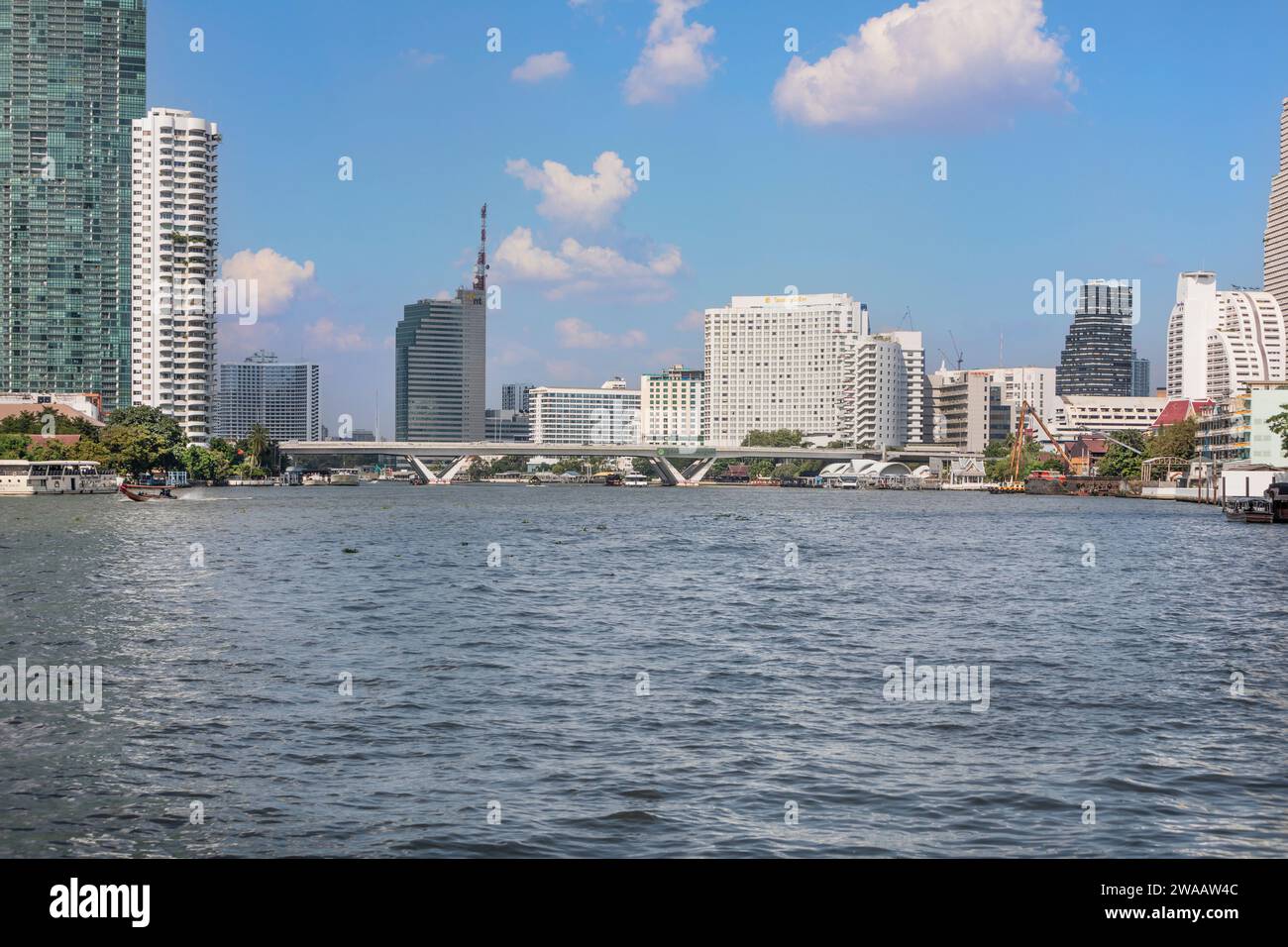 A cityscape of Bangkok, Thailand taken from the Chao Phraya river with ...
