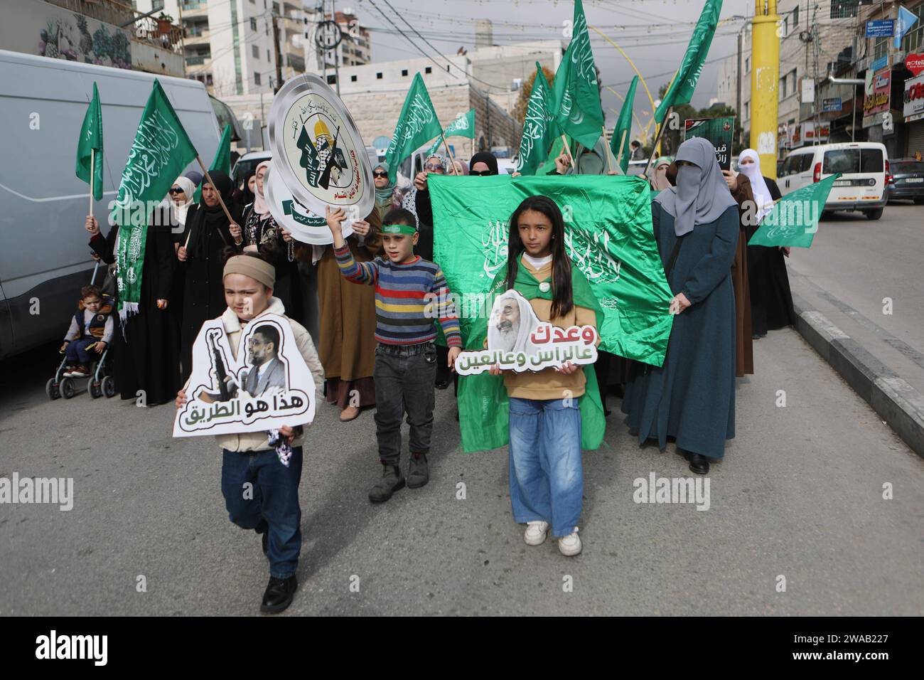 Palestinian protesters with the green flags of Hamas shout slogans ...
