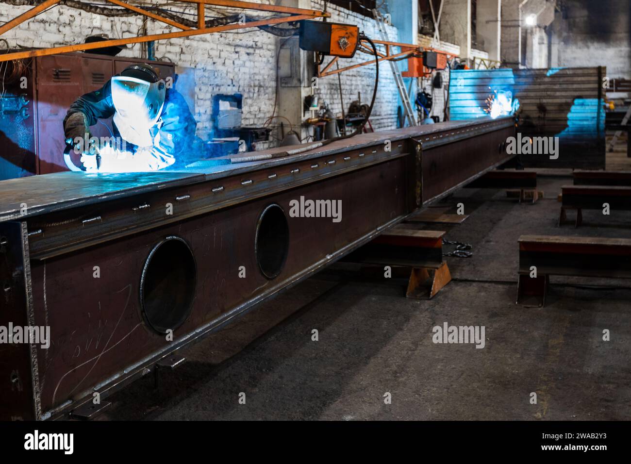The welder works in the workshop. The moment of welding of metal ...