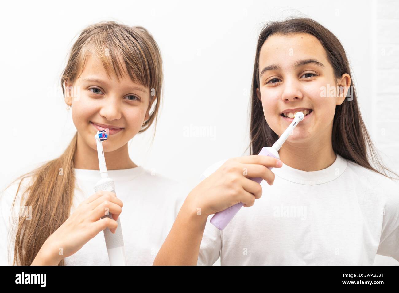 Portrait of two beautiful girls kids with perfect smile holding ...