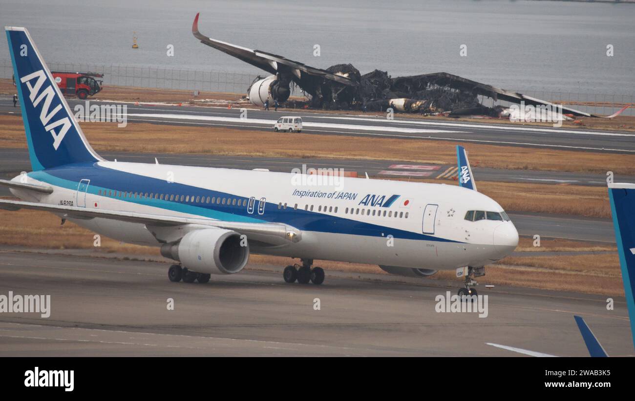 Tokyo, Japan. 03rd Jan, 2024. An ANA plane taxis as officials ...