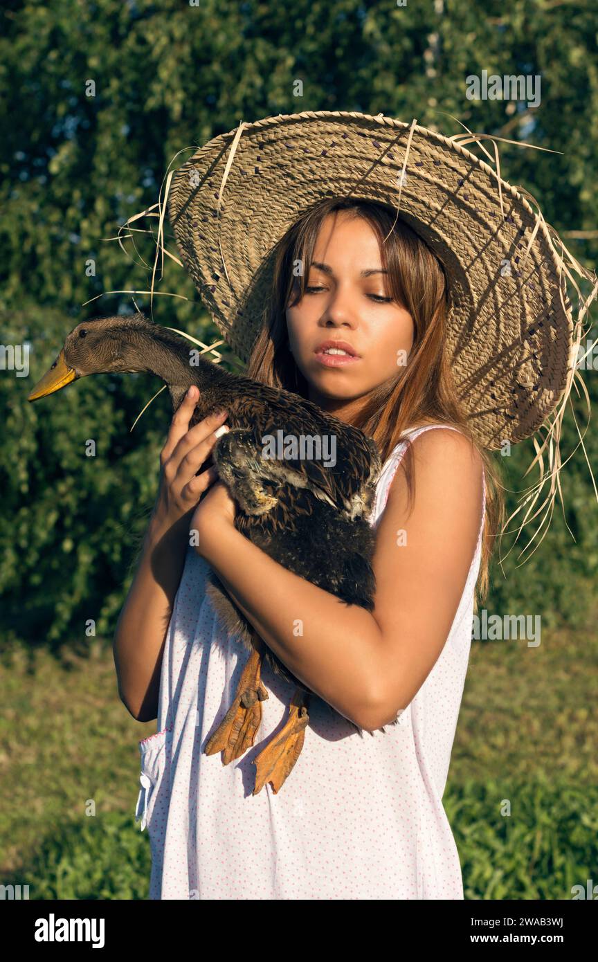 Girl in a hat with a goose Stock Photo - Alamy