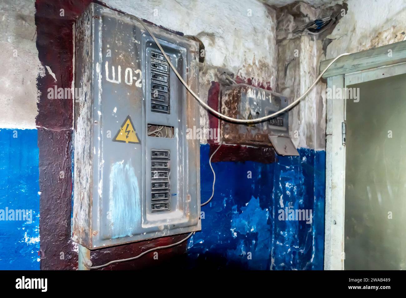 Old Soviet run-down electricity switchers on the battered wall tackily ...