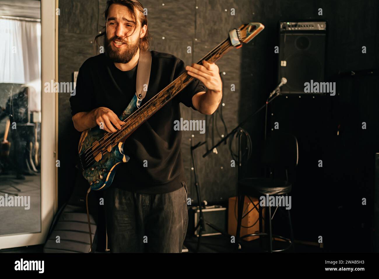 Guitarist plays electric guitar and sings at rehearsal in recording ...