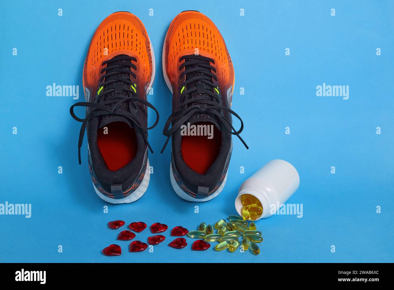 Scattered yellow vitamin D capsules from a jar and red decorative ...