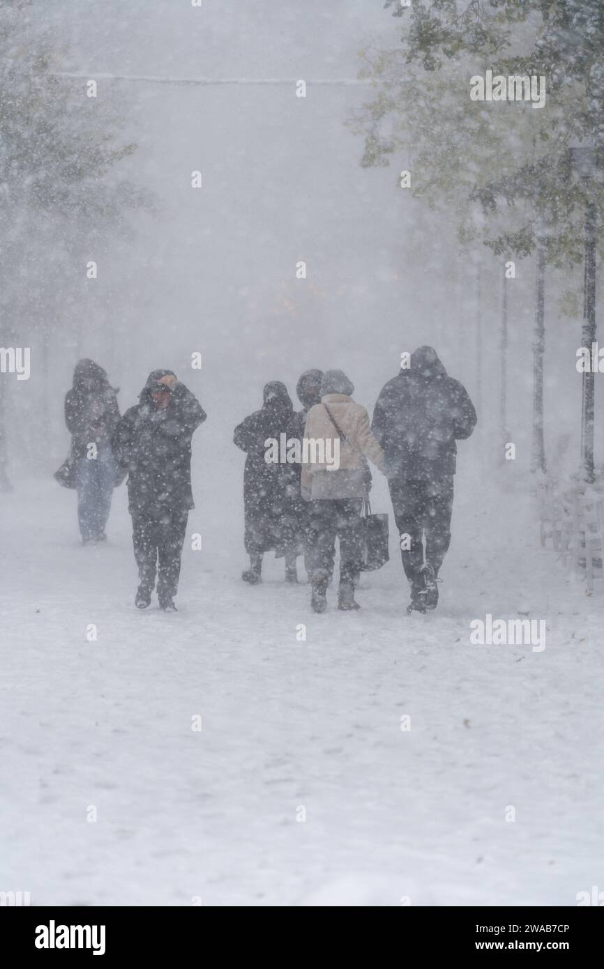 Group of people walking in the snow storm on the city streets Stock ...