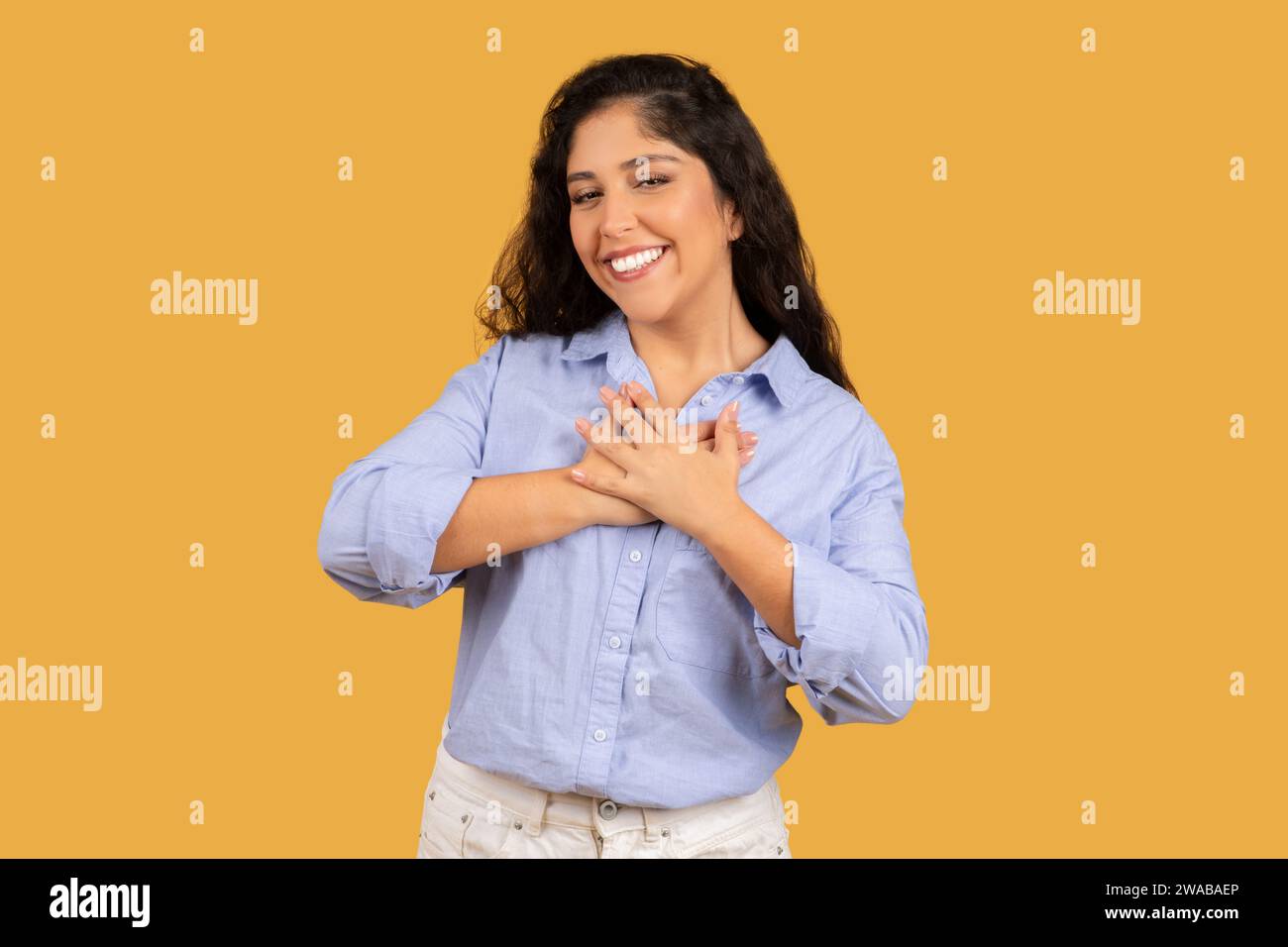 Content young woman with wavy hair, hands crossed over chest, smiling ...