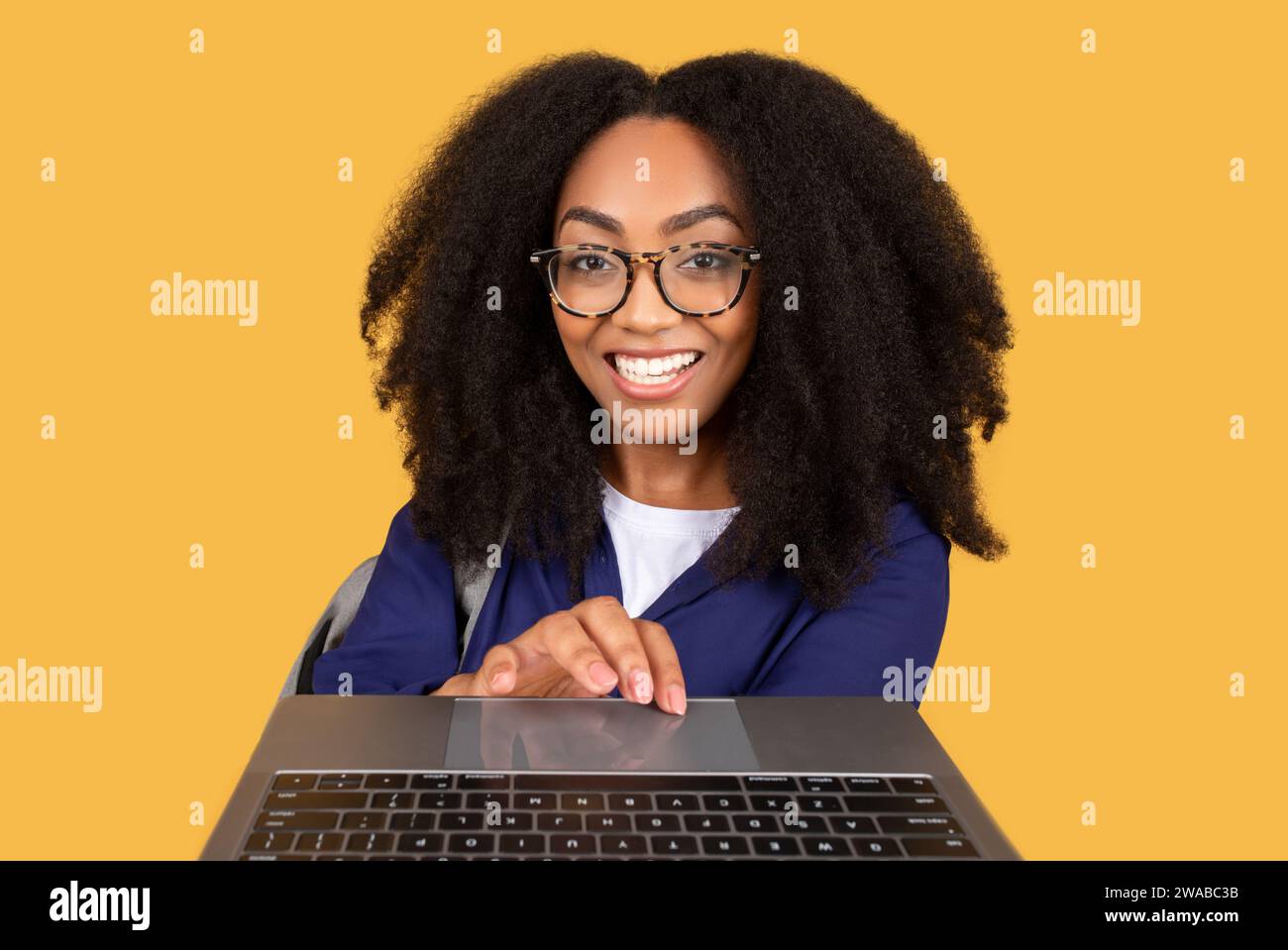 Cheerful black lady student typing at keyboard laptop and smiling on ...