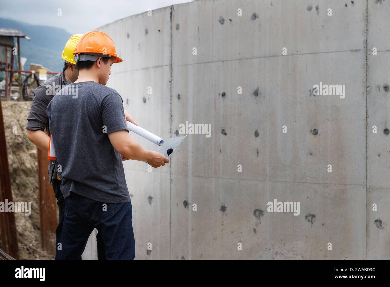 Team of construction workers discussing project details with blueprint ...