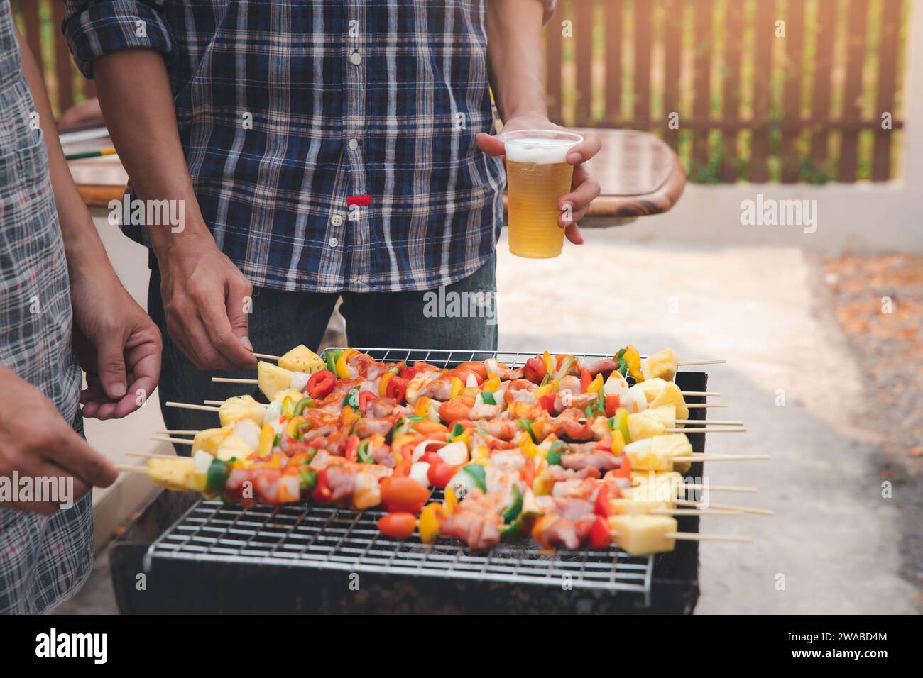 A man grilling pork and barbecue in dinner party. Food, people and ...