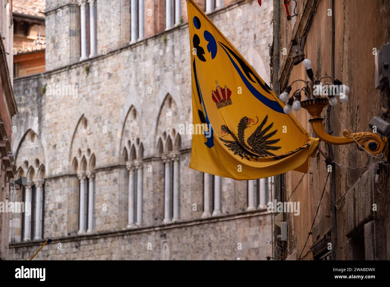 Contrade flags of the Aquila-Eagle district hanging in a street of ...