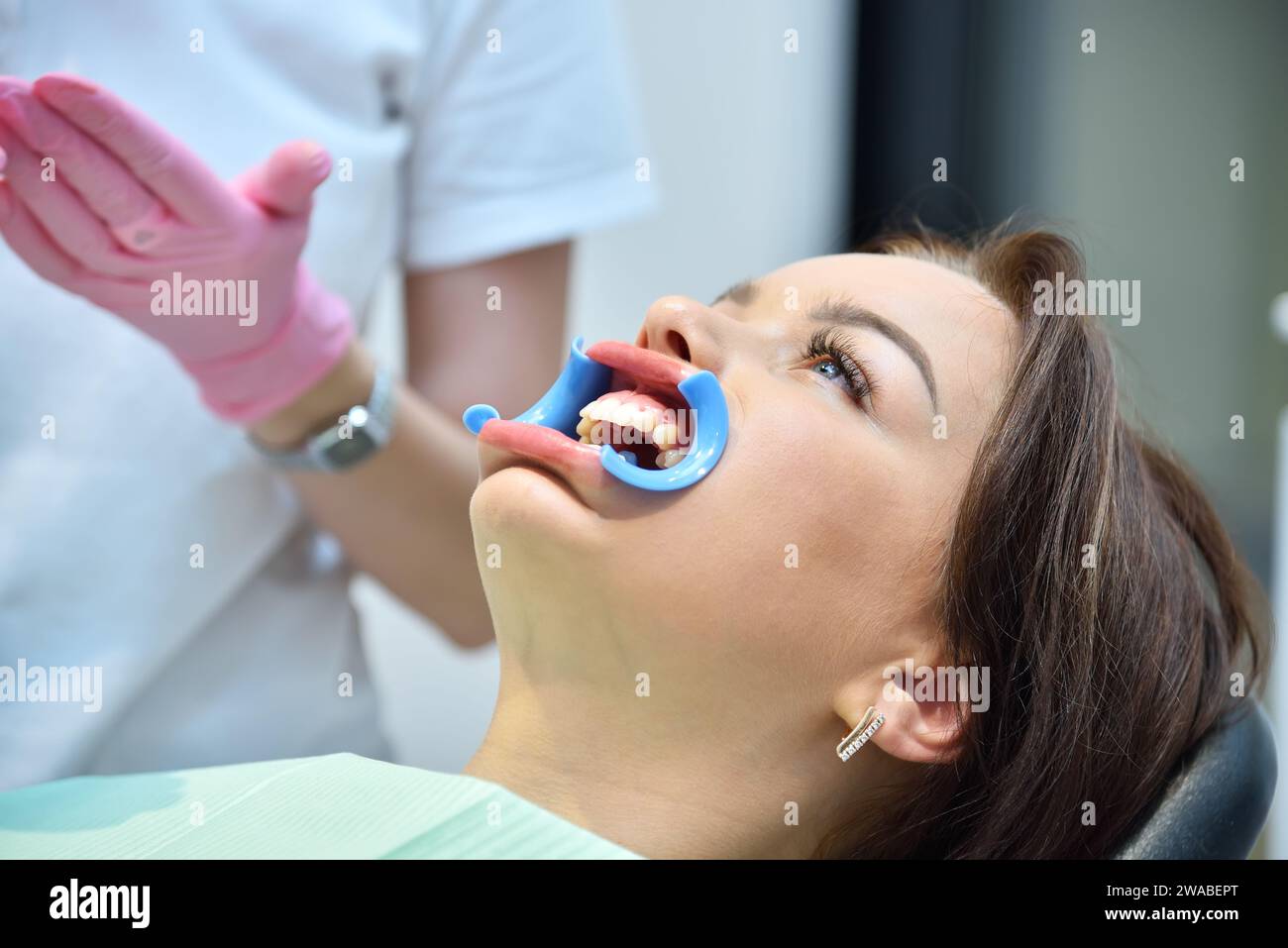 Patient with a dental retractor in mouth on examination at dentist in ...