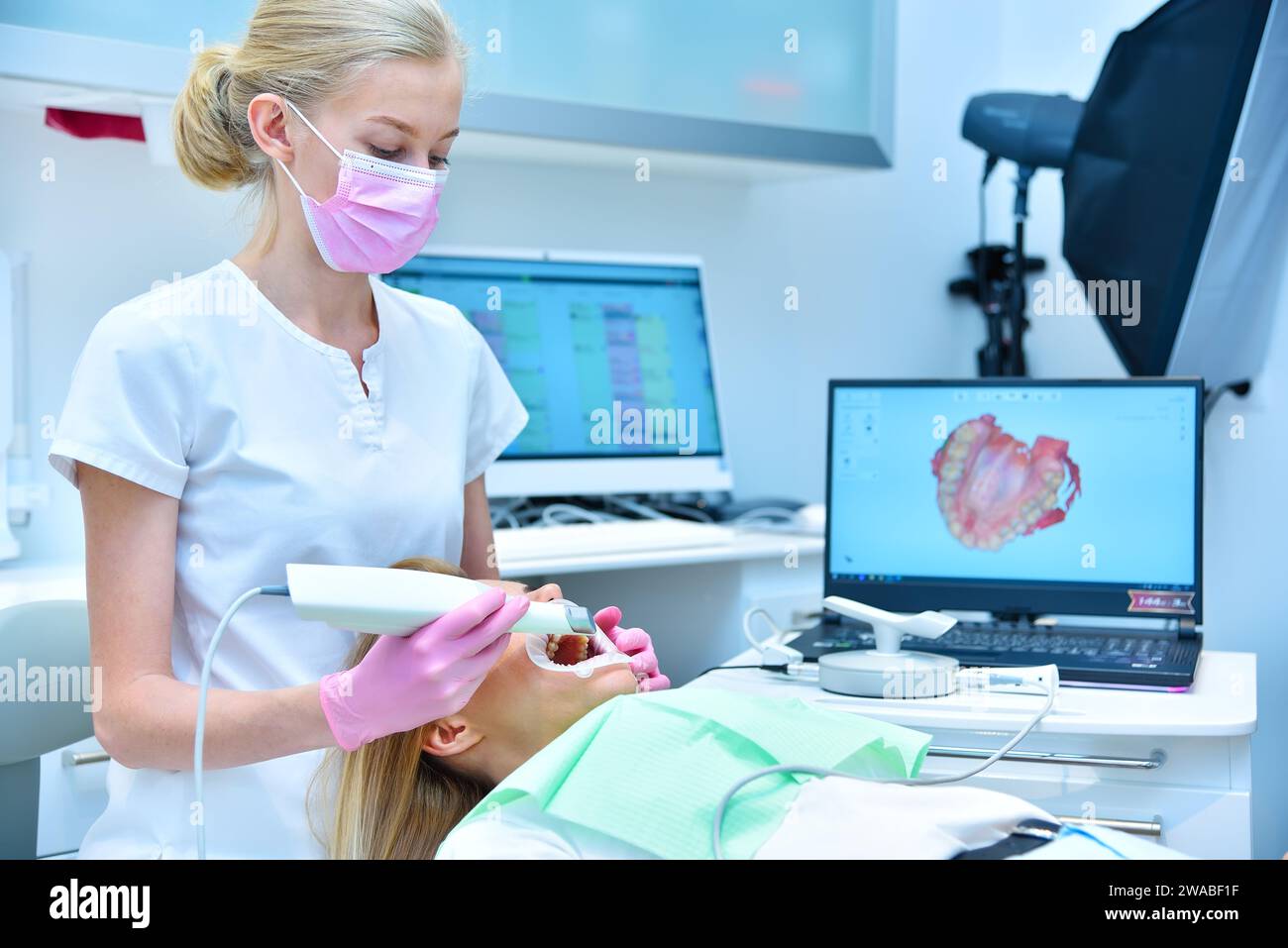 Dentist scaning patient with dental intraoral scanner and controls ...