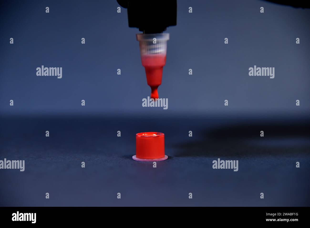 Red ink dripping in plastic cup. Art And design concept. Close up Stock ...