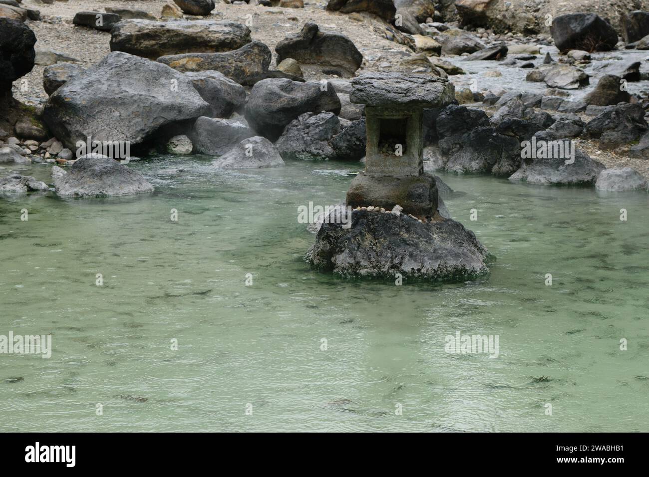 A lantern on a stone surrounded by Japanese onsen water Stock Photo - Alamy