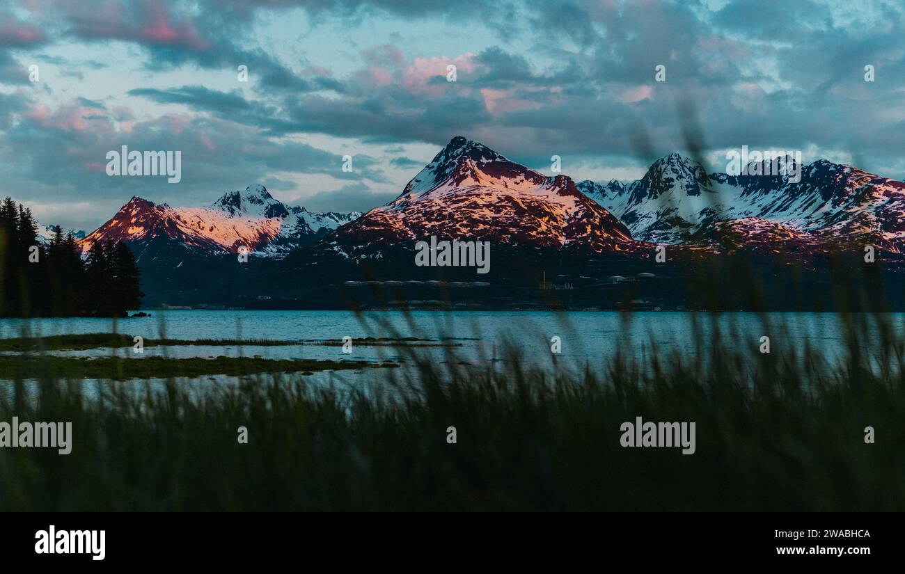 Sunset bursting with colors over lakeside mountains in Alaska Stock ...