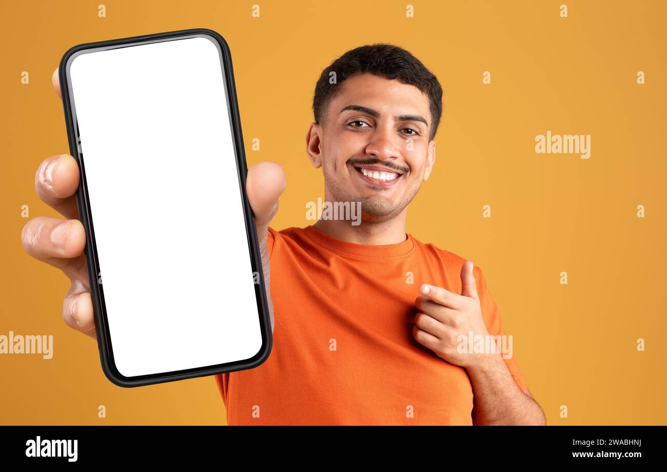 Cheerful man showing big cell phone with white blank screen Stock Photo ...