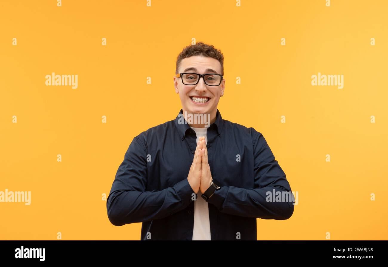 Pleading begging young man holding hands folded in prayer Stock Photo ...