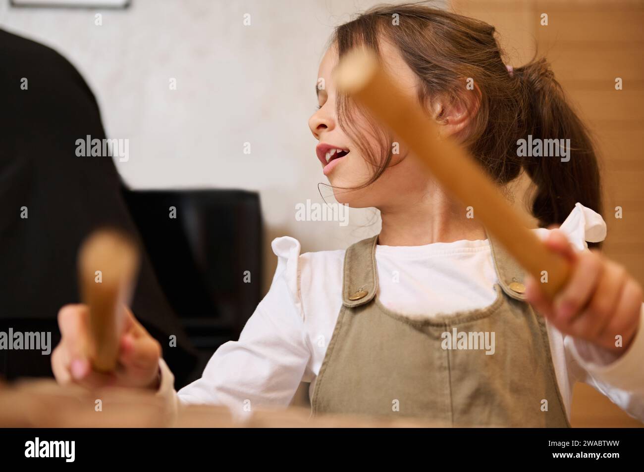Caucasian adorable little kid girl playing wooden xylophone, holding ...
