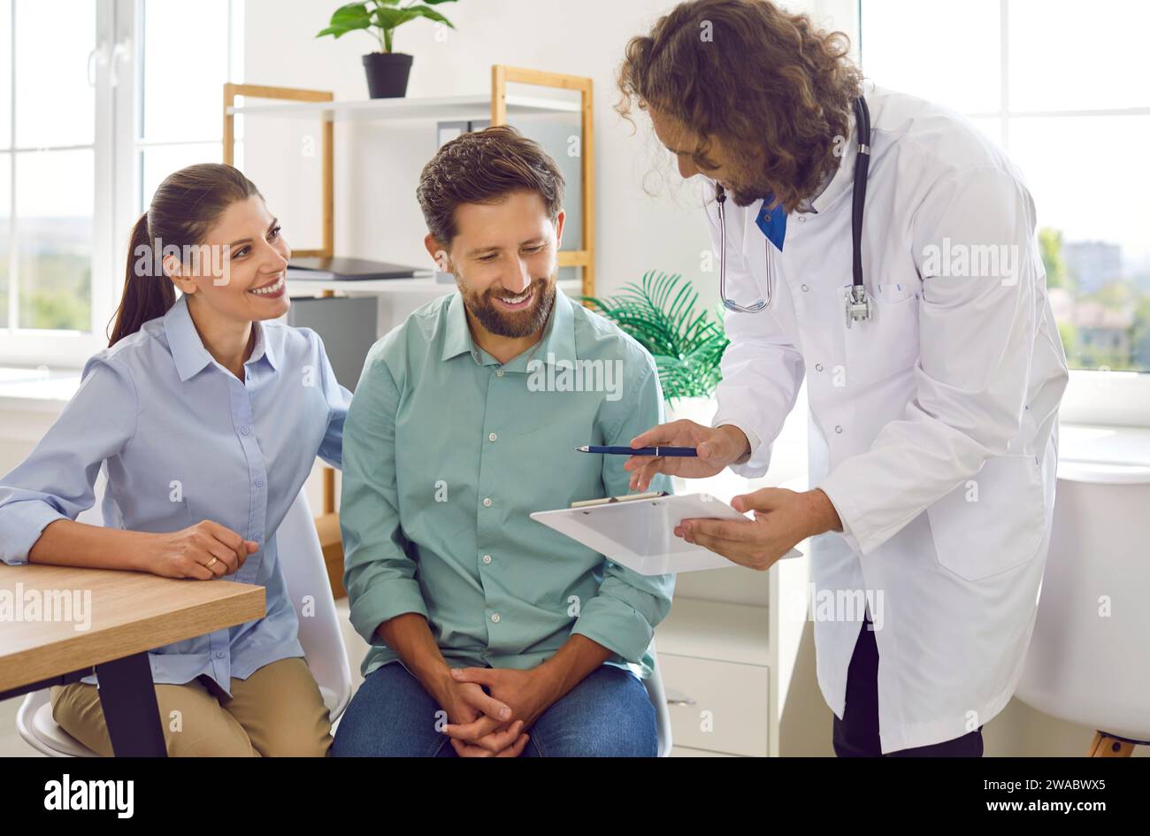 Friendly gynecologist advises couple on pregnancy and shows them ...